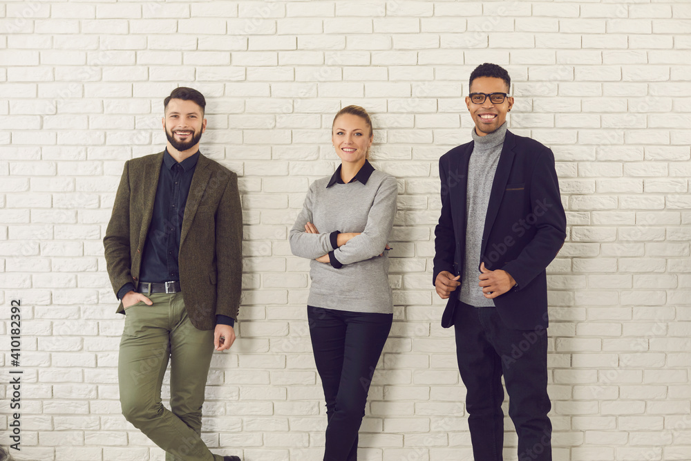 Group portrait of smiling young diverse coworkers, company managers or ...
