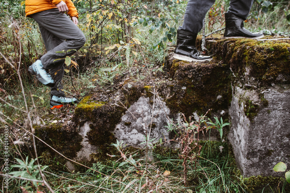 Legs of two people walking on a vintage staircase with moss in the ...