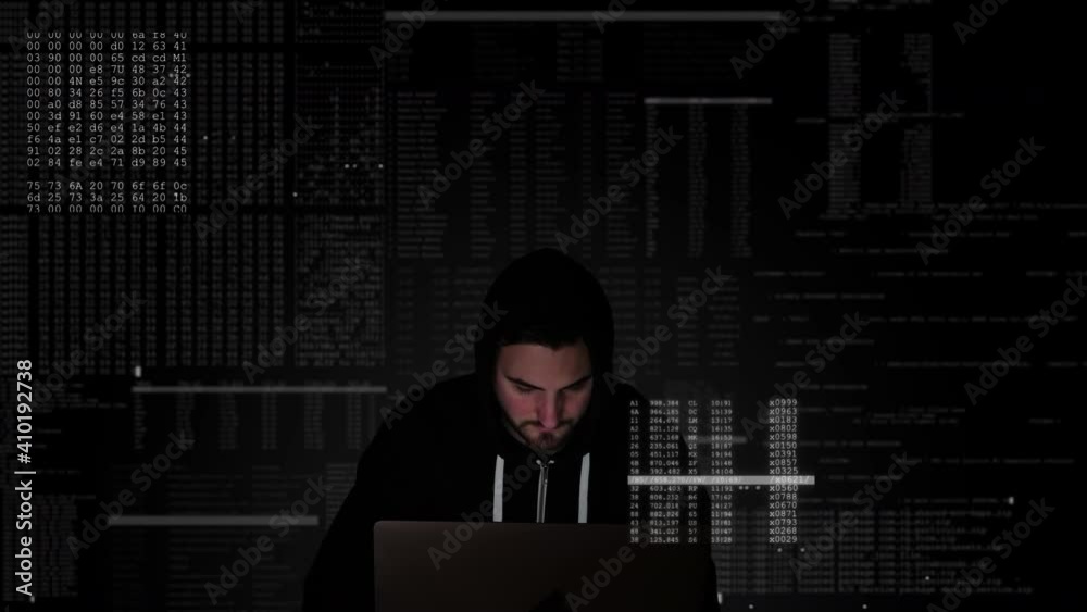 Black hooded hacker in midst of computer code is frantically typing on ...