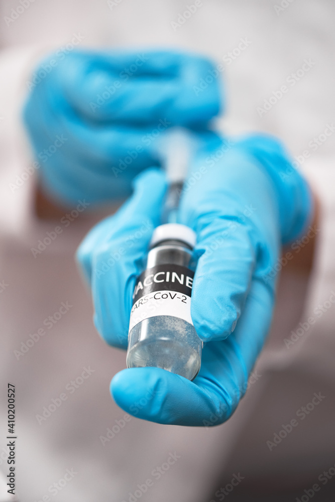 Doctor dials the vaccine into a syringe Stock Photo | Adobe Stock
