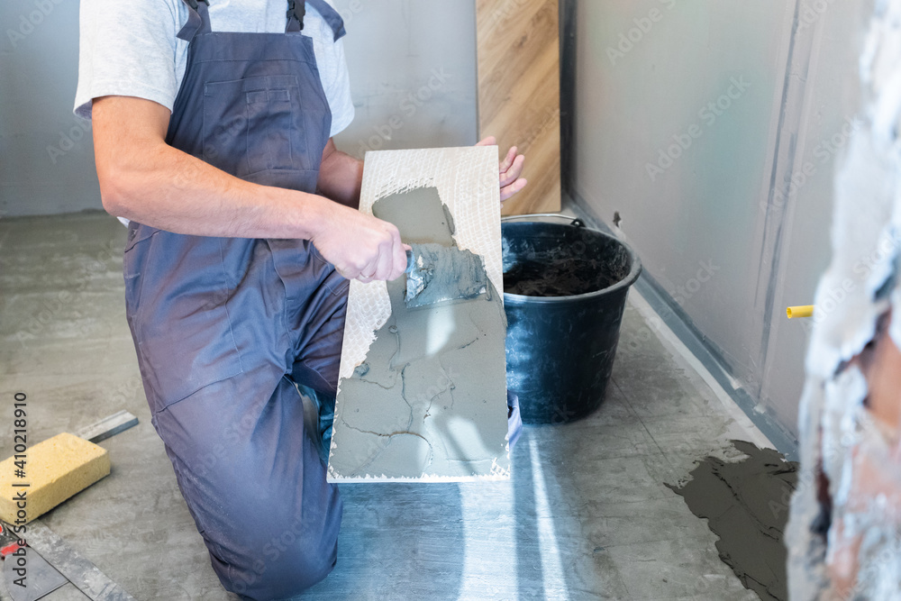 The process of laying ceramic floor tiles with a herringbone pattern ...