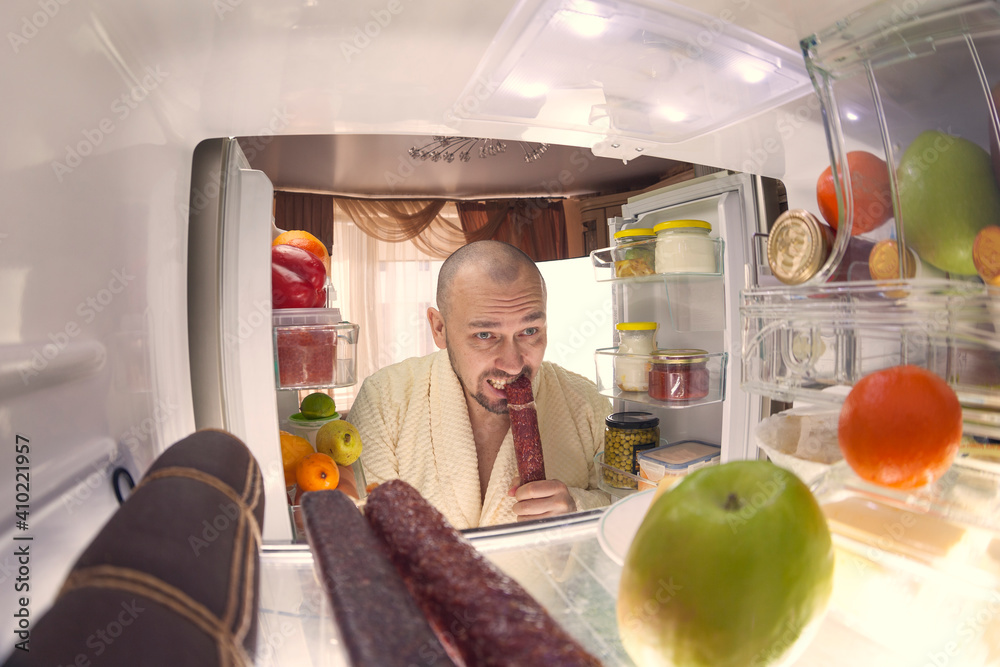 hungry man, Violation of the diet. A man looks at the refrigerator at ...