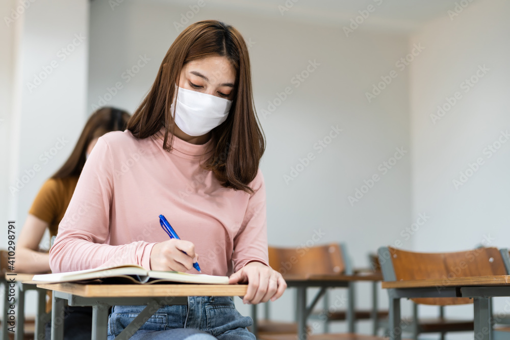 Group of college students wearing a face mask and keep distance while ...