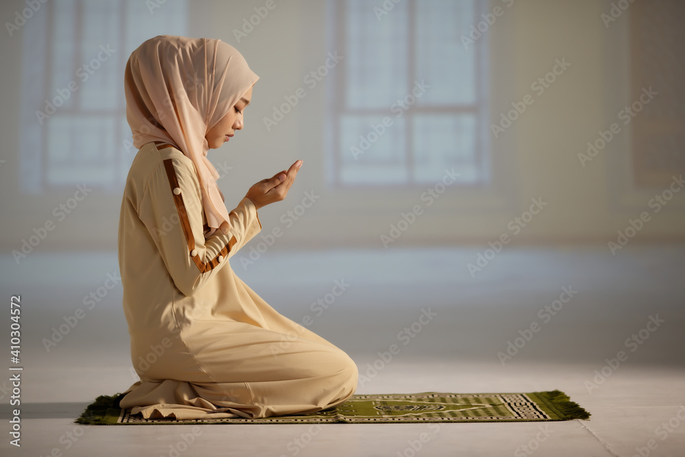 Beautiful Muslim woman in hijab dress sitting in mosque and praying ...