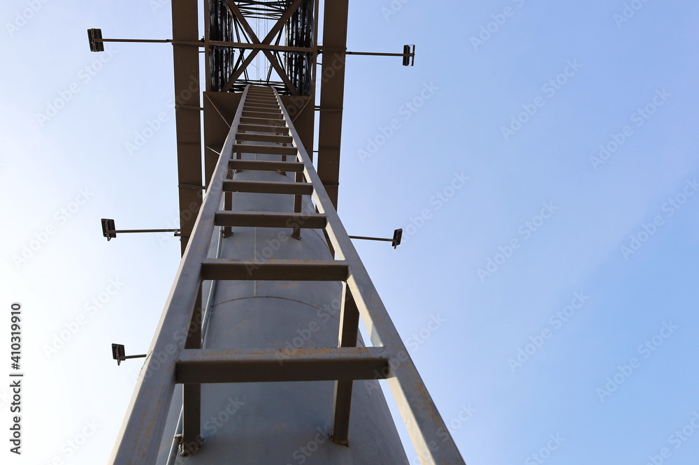 Billboard ladder. A colored ladder on a metal pillar of a large ...