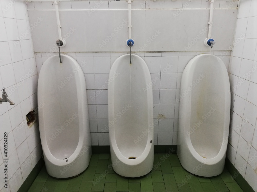 The interior of old dirty Public toilet urinals in men toilet with very ...