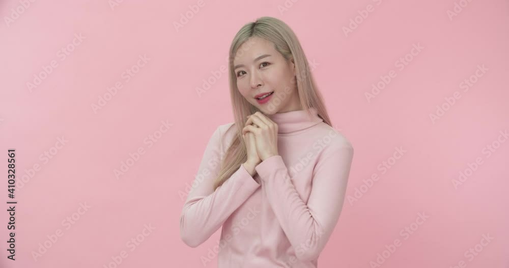 Portrait of young shy and beautiful Asian woman in pink long sleeve t ...