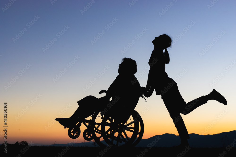 Silhouette Disabled handicapped young man in wheelchair walking with ...