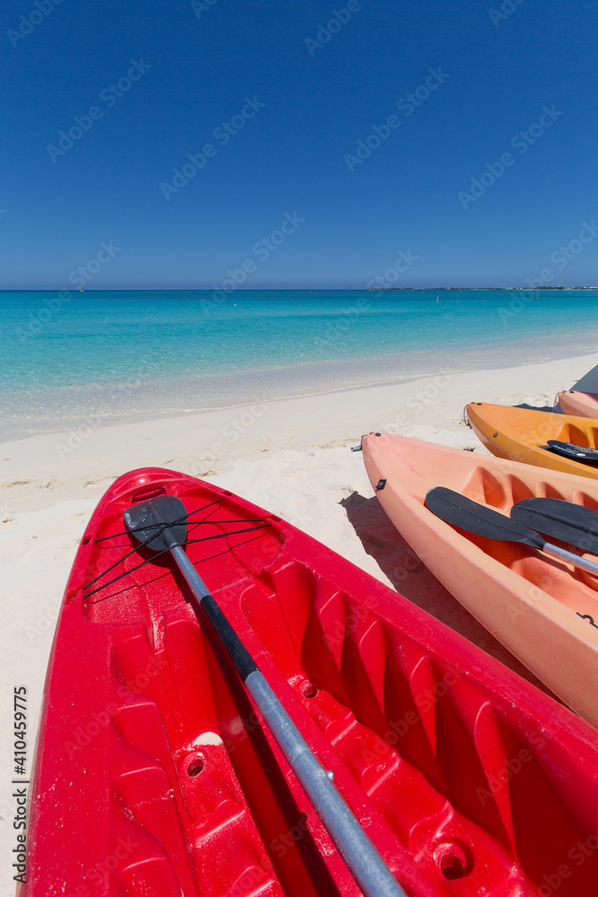 Colorful red kayaks with paddles on a tropical beach on summer day ...