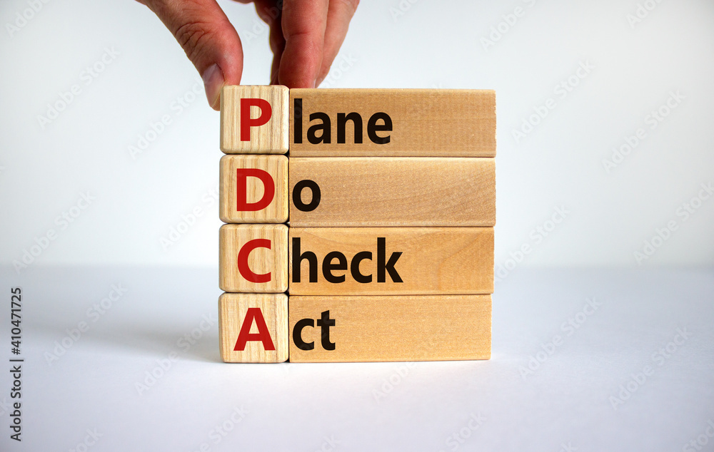 PDCA, plan do check act symbol. Businessman hand. Wooden cubes and ...