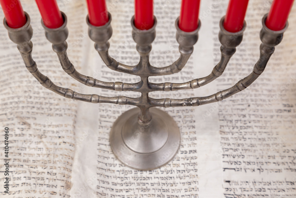 Old scrolls of the Bible and Menorah lie on a black background ...