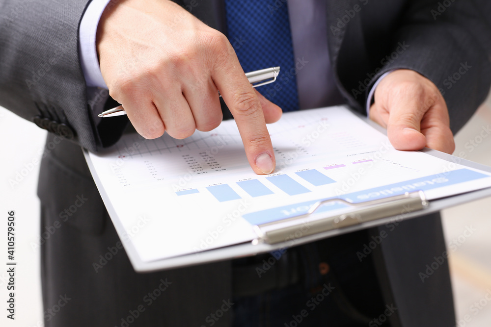 Hand of businessman in suit filling and signing with silver pen ...