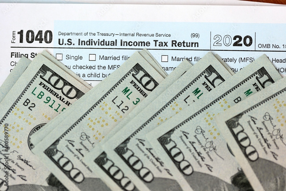 One hundred dollar bills and US 1040 tax form. Calculating your tax ...