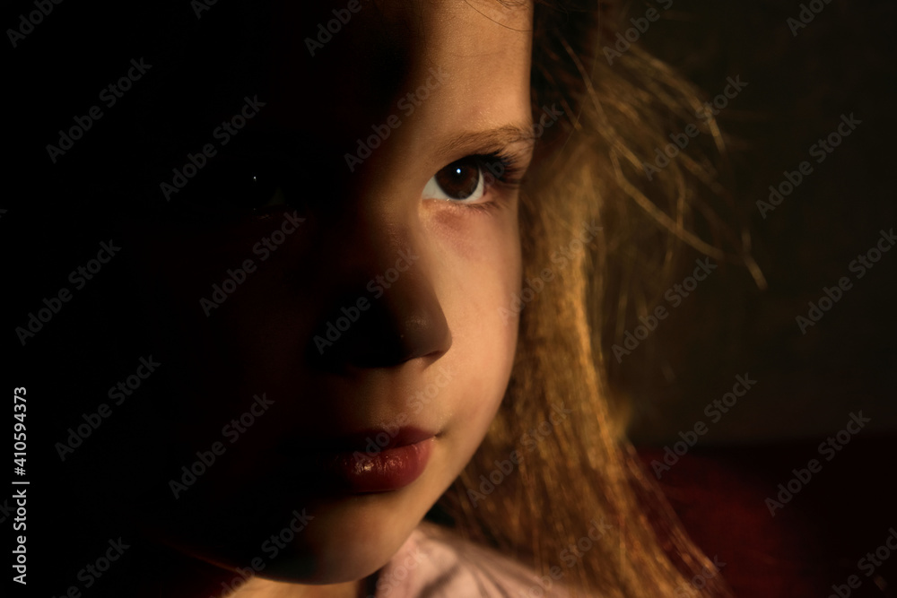 Powerful low key image of little girl in dark side with shadow on face ...