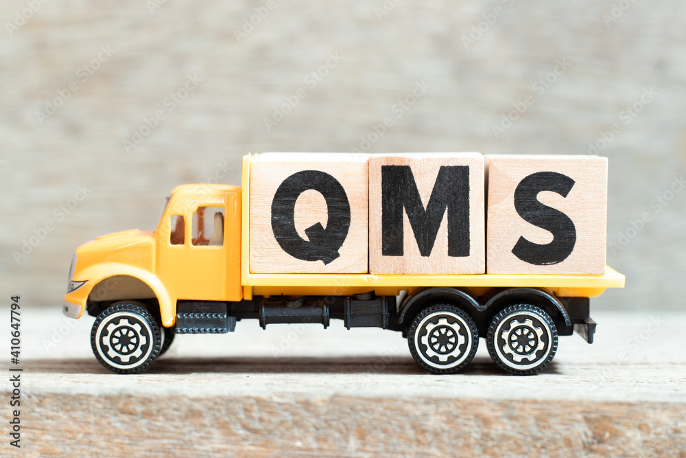 Toy truck hold alphabet letter block in word QMS (abbreviation of ...