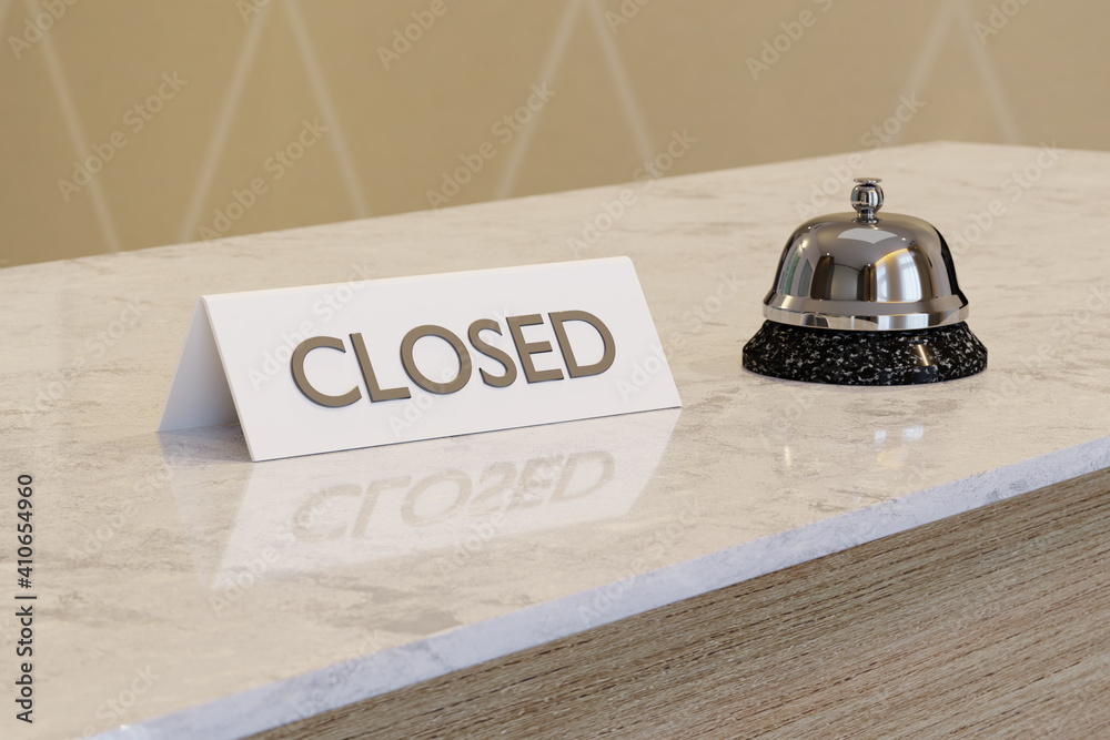 Closed sign on the white marble table of a hotel reception desk with a ...