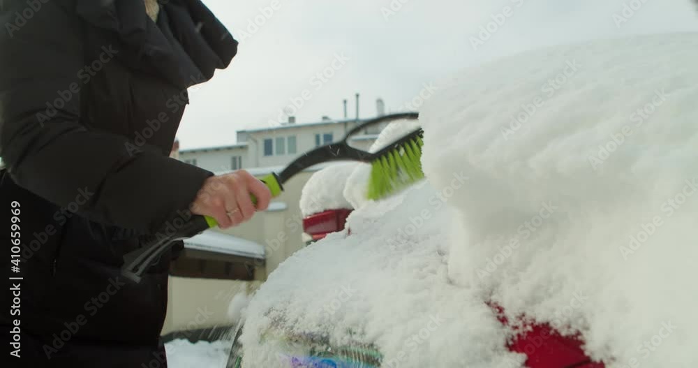 Vidéo Stock Cute young blonde woman cleans the car from the snow ...