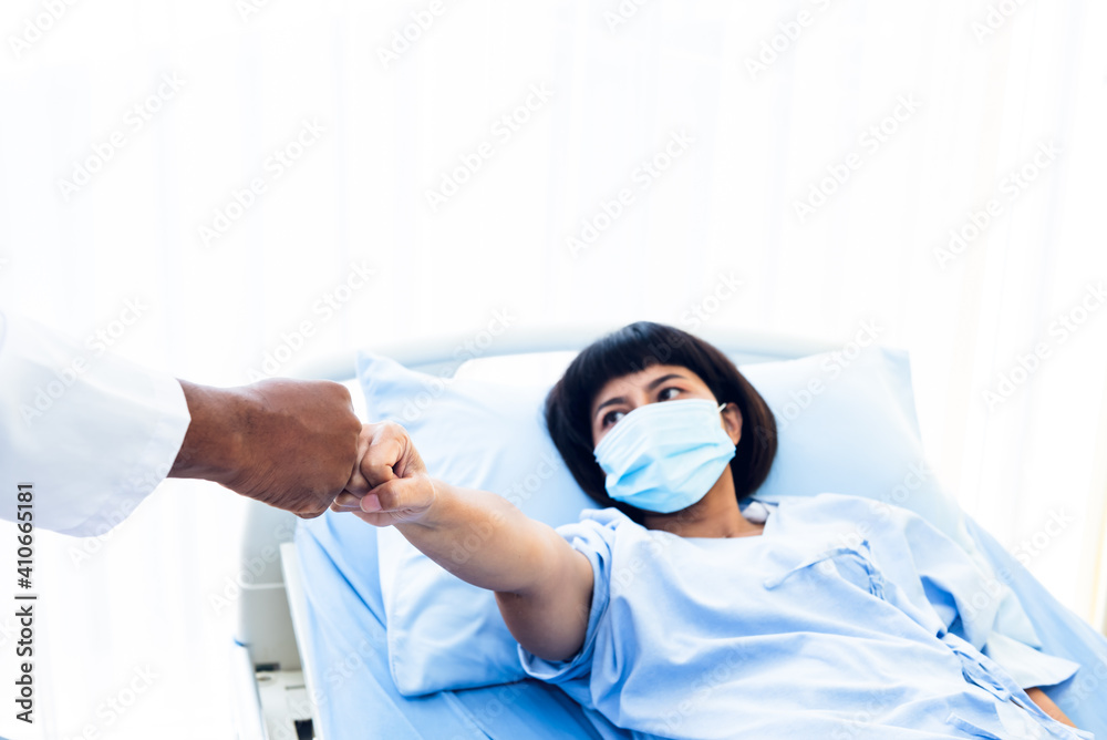 Doctor and patient are use hands fist bump to show encouragement ...