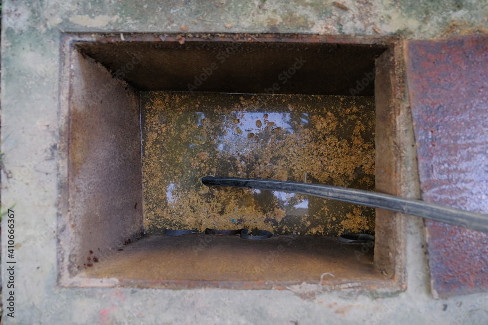 The worker clears the clogged sewer drain using drain clog remover ...