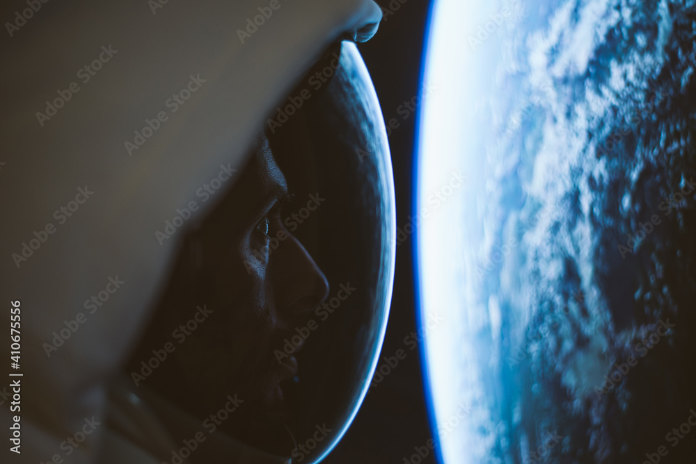 Astronaut looking deep space, galaxy and planets from the window of his ...