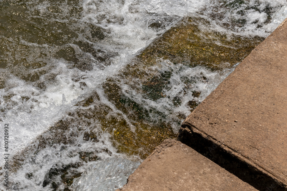The water flow passes the weir from upper level to lower level the side ...
