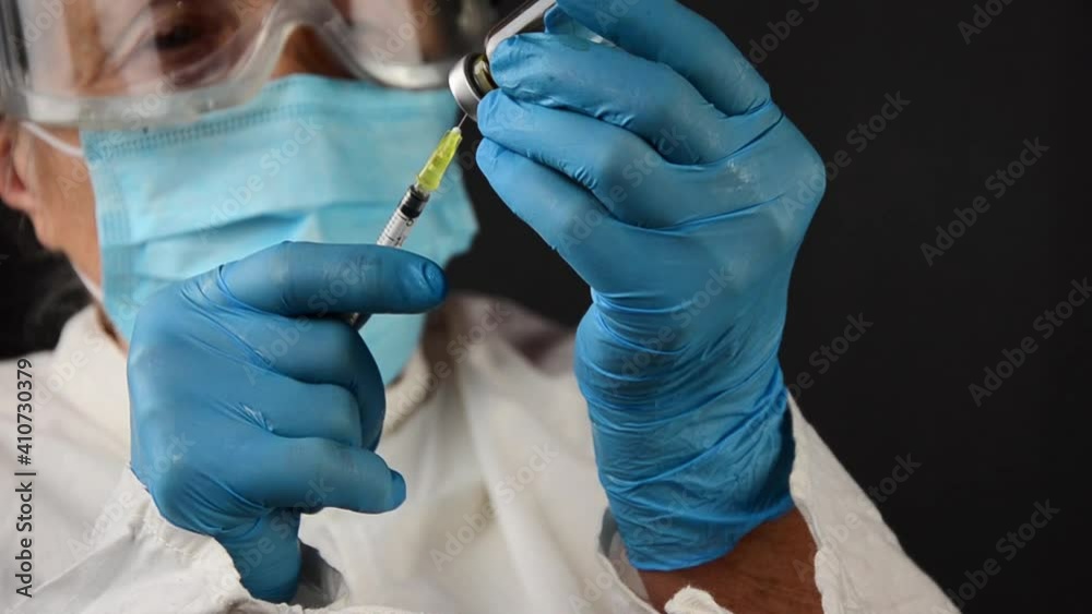 The doctor draws the vaccine into a syringe.Testing a vaccine against ...
