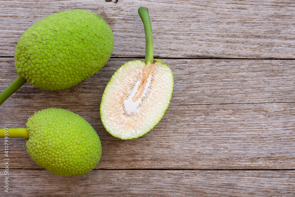 Breadfruit ( Artocarpus altilis ) with cut in half slice on wood table ...