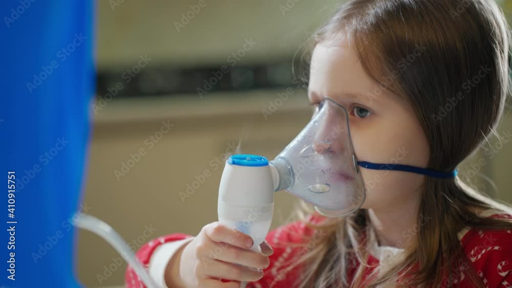 Teenage girl breathes in an oxygen mask. Inhalation of the respiratory ...