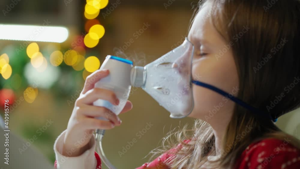 Teenage girl breathes in an oxygen mask. Inhalation of the respiratory ...