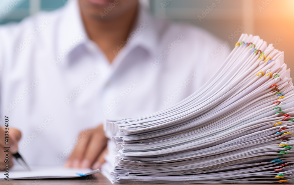 Male office workers holding and writing documents on office desk with ...