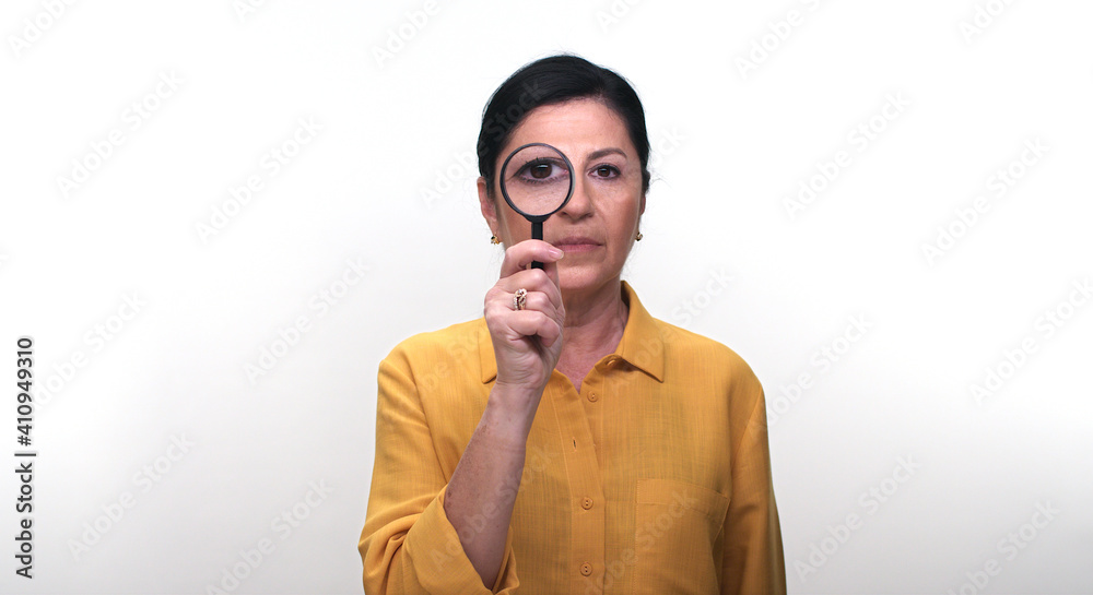 Elderly old woman with magnifying glass looking at camera. The old lady ...