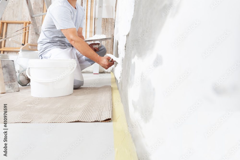 Hands man plasterer construction worker at work closeup, takes plaster ...