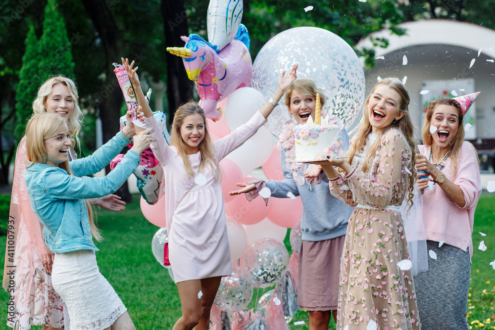 Six girls have fun at a birthday party in the park. They're wearing ...