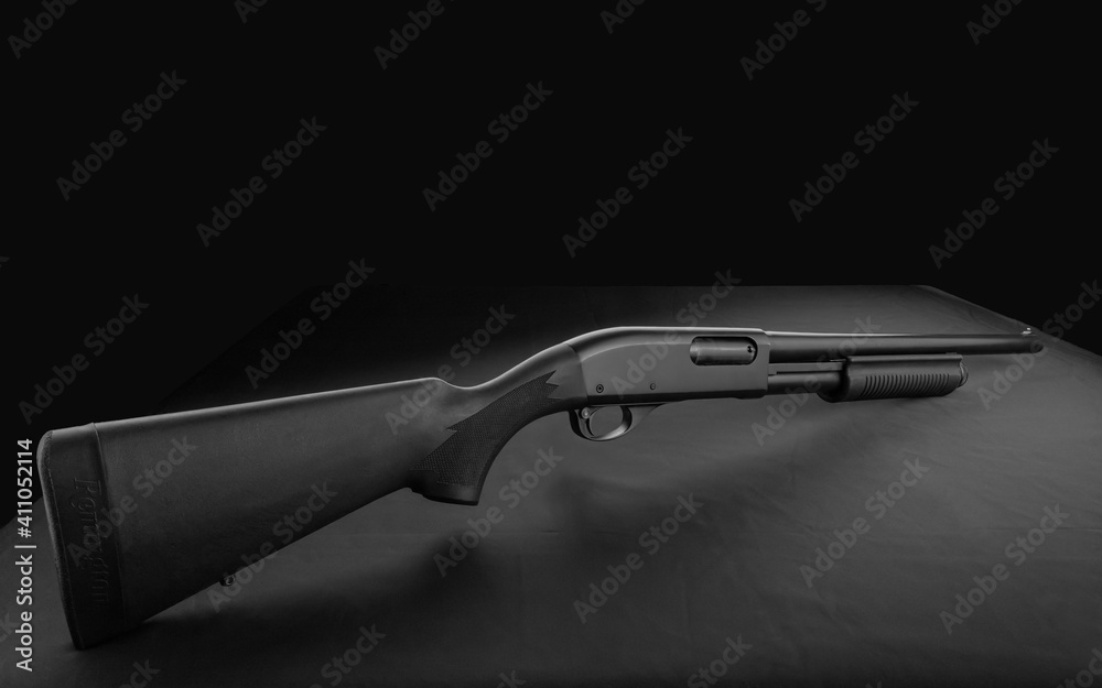 Black synthetic hardware pump action shotgon photographed on an all ...