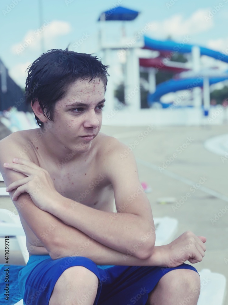 Shirtless Boy Looking Away While Sitting At Beach Stock Photo | Adobe Stock