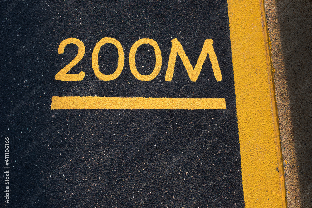 200M (meters) sign, with yellow letters and line marked on a asphalt ...