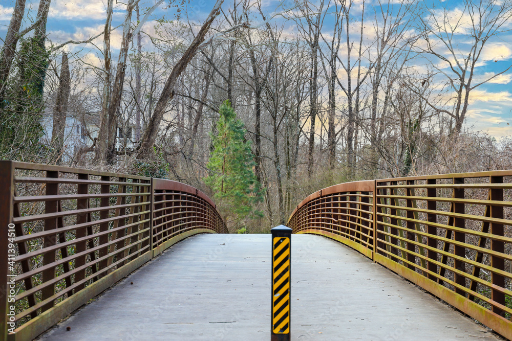 a long brown and yellow iron bridge with smooth concrete pavement ...