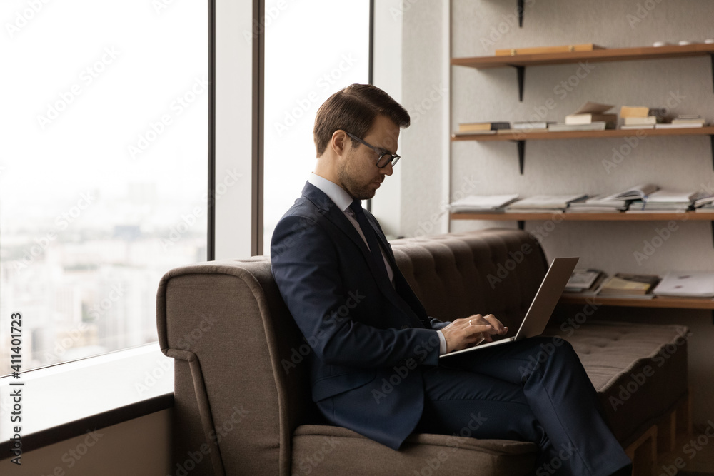 Confident businessman in formal suit and glasses work on laptop hold ...