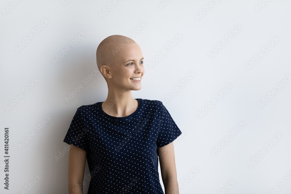 Smiling hairless female cancer patient isolated on grey studio ...