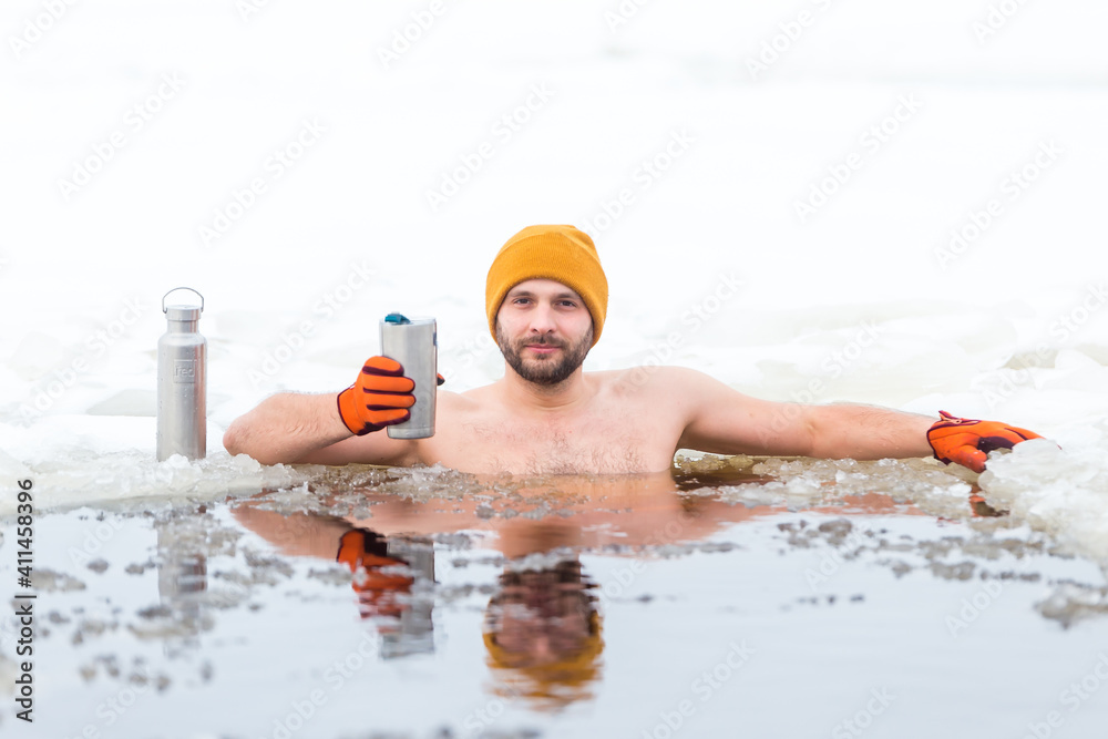 Happy man doing cold baths in winter with hot tea in a thermos. Cold ...