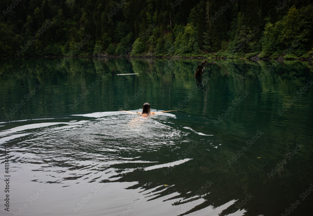 A young woman swimming in a lake on a smoky evening Stock Photo | Adobe ...