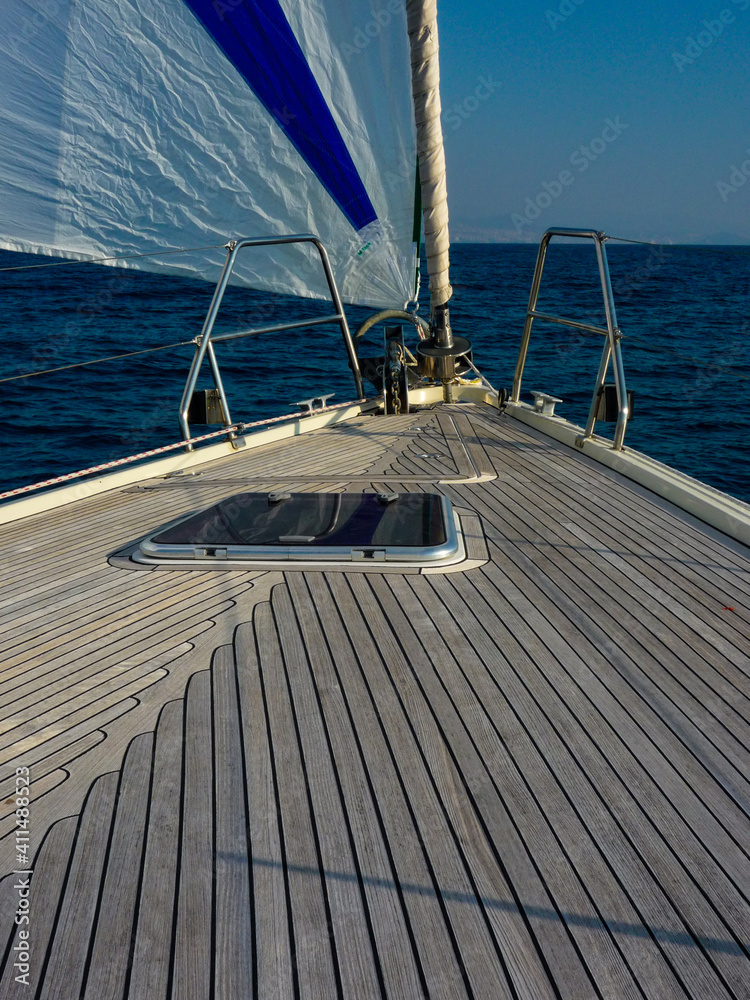 Aboard a sailboat yacht with teak deck and main sail and genoa sailing ...