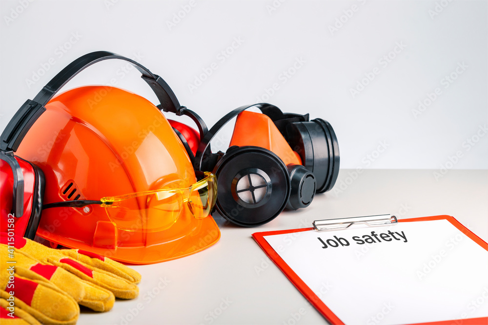Job safety write on a clipboard and personal protective equipment on ...