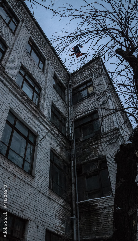 Brave man jumping from roof to roof. Guy doing scary jump between roofs ...