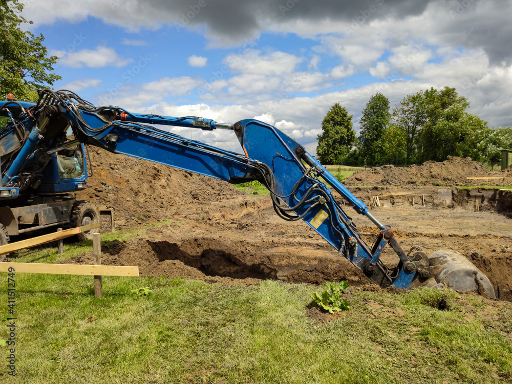 A work excavator digging a trench for the foundation of a building ...