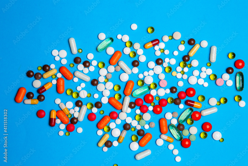 Antiviral capsules, tablets for treatment lie on a blue background ...