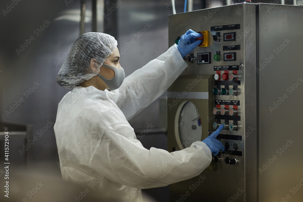 Side view portrait of young woman pushing buttons on control panel ...