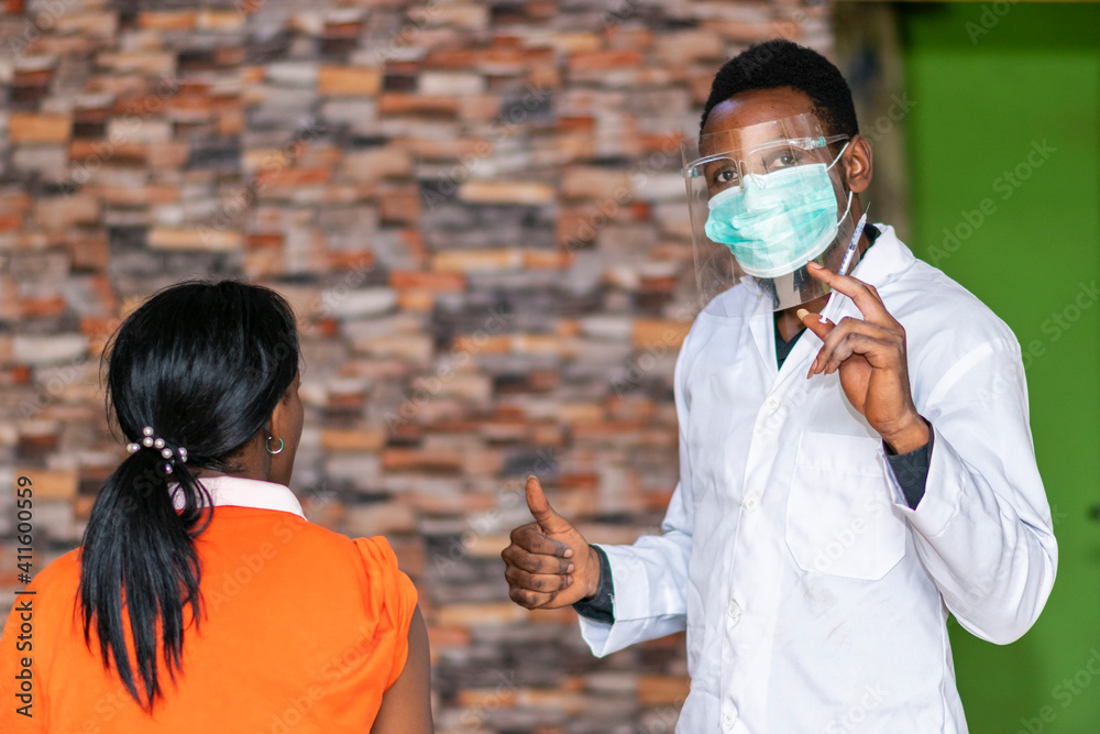 medical personnel wearing face mask and shield gives a thumbs up after ...