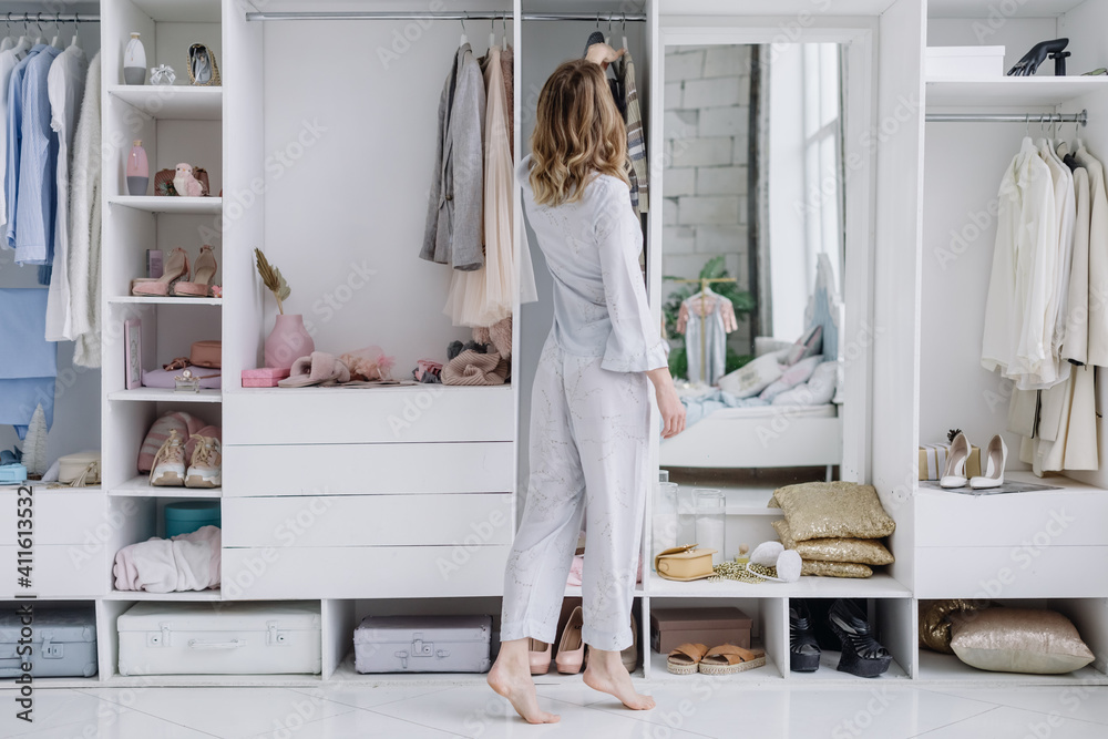 Young woman chooses a dress in her modern dressing room Stock Photo ...