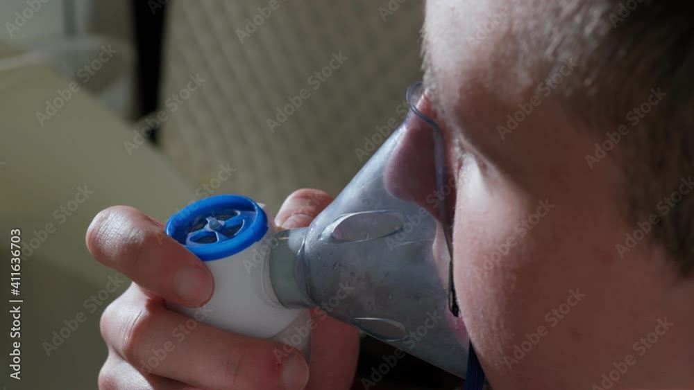 Teenage boy breathes in an oxygen mask. Inhalation of the respiratory ...